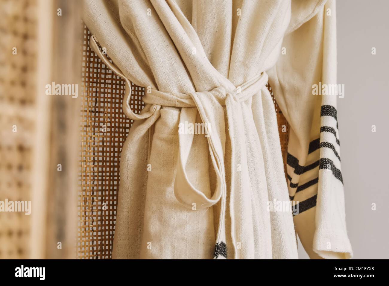 a white robe with black and brown stripes on it, sitting on a wooden ...