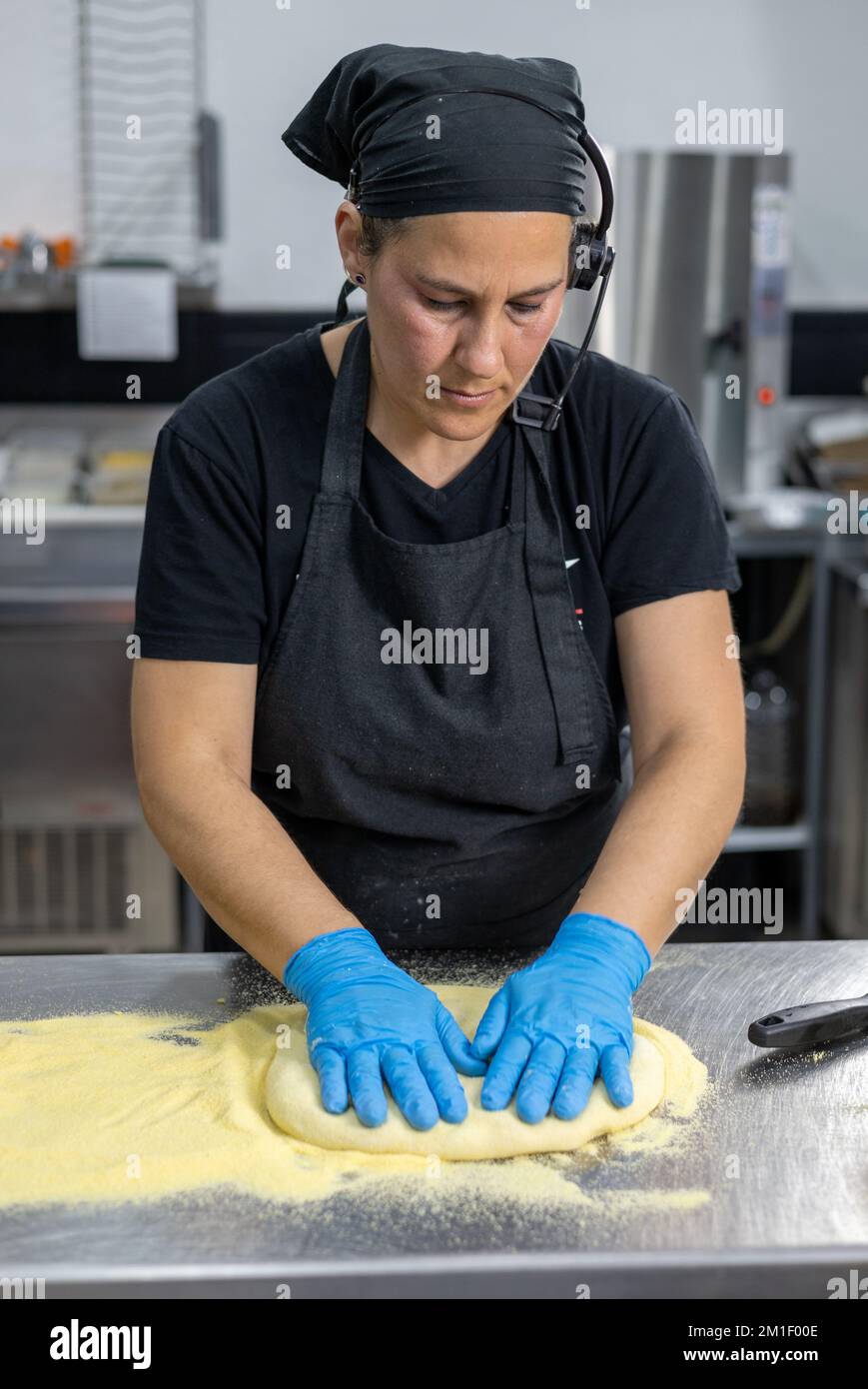 Professional woman chef stretch and rolling out dough for pizza Stock ...