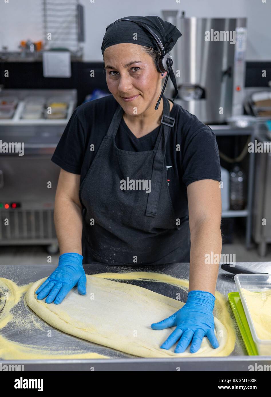 Professional woman chef stretch and rolling out dough for pizza Stock ...