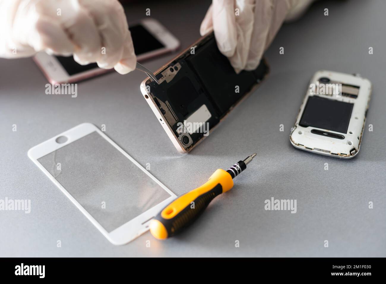 The technician repairing the smartphone's motherboard in the lab with ...