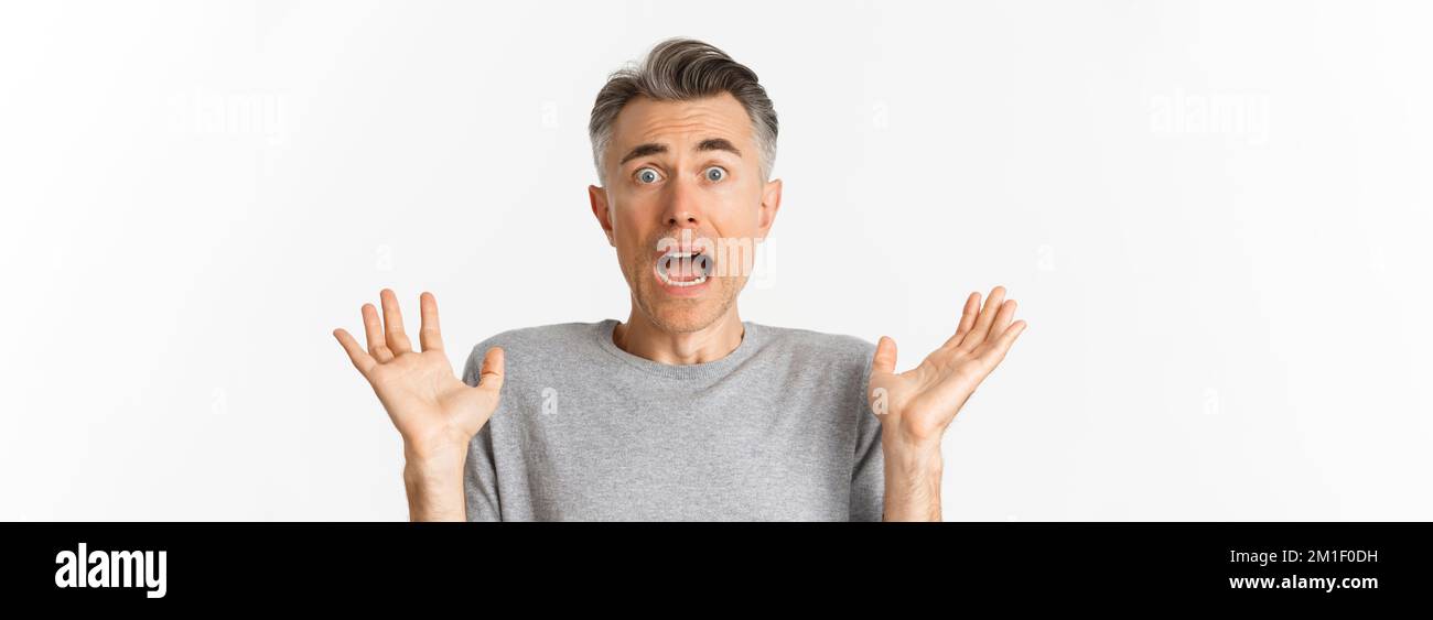 Close-up of scared middle-aged man, looking startled, jumping and ...