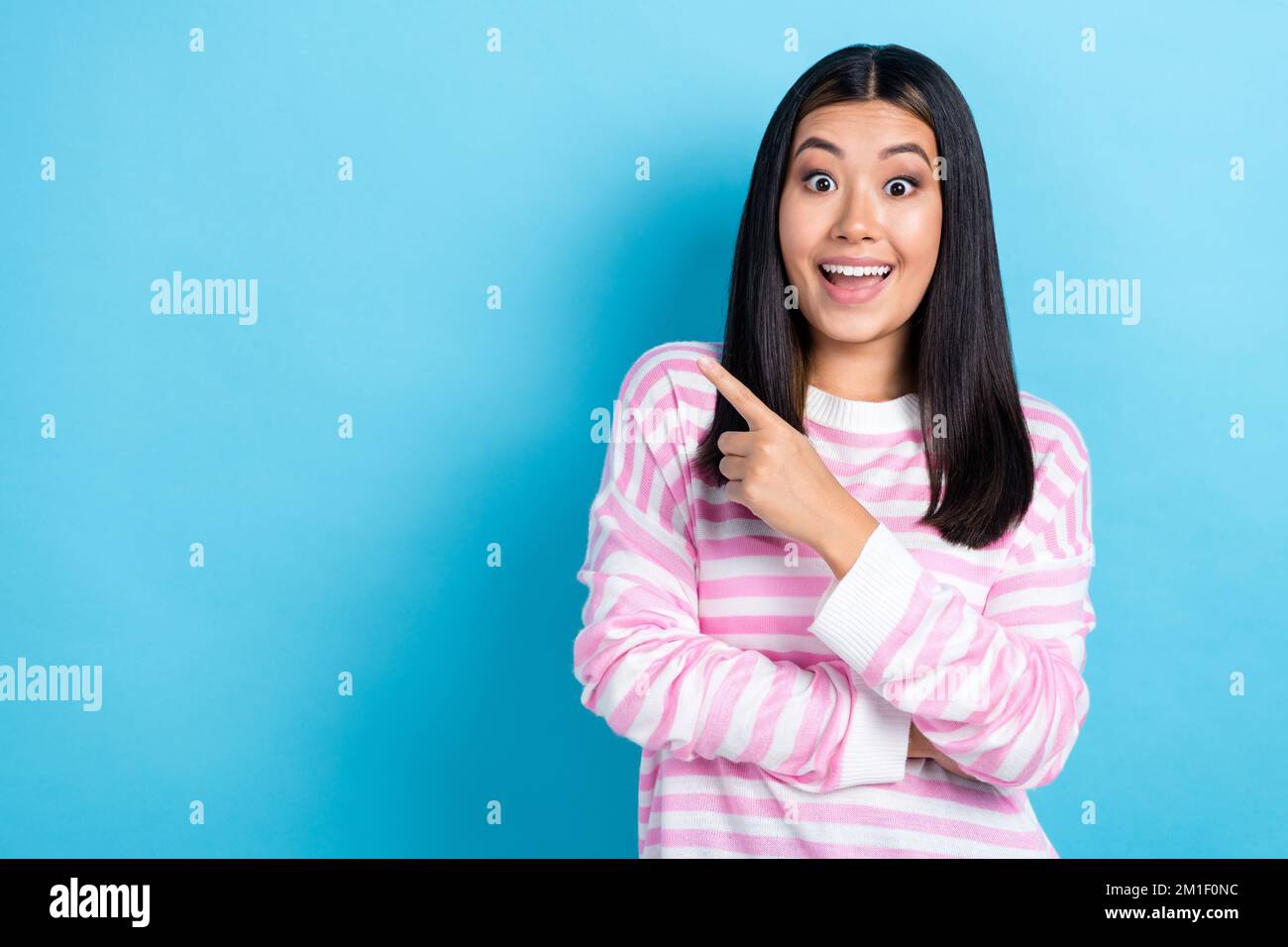 Photo of cheerful impressed young girl dressed pink pullover pointing ...