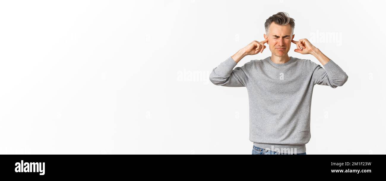 Portrait of annoyed and distressed middle-aged man, grimacing from loud ...