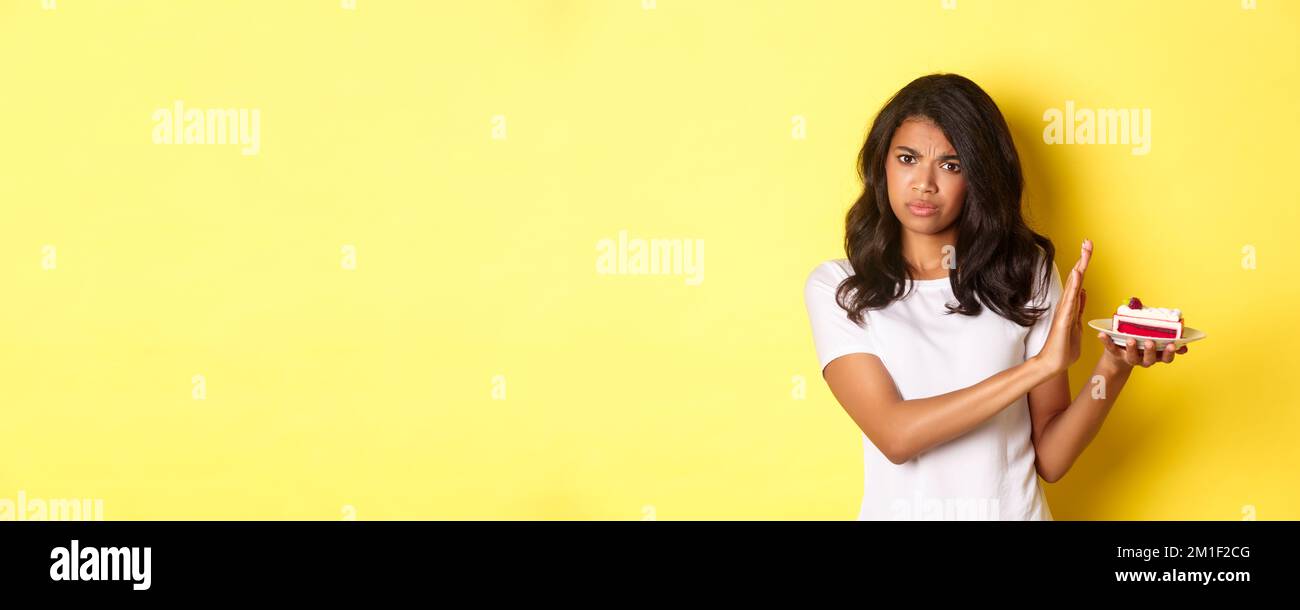 Image of displeased african-american girl decline to eat a cake ...
