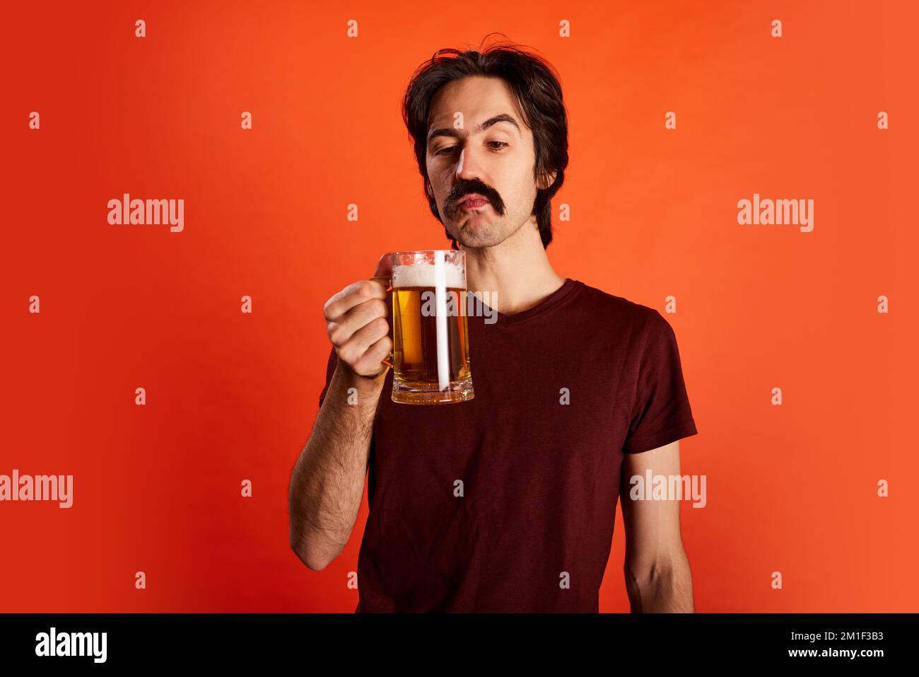Portrait of emotive man with moustache posing with glass of cool, foamy ...