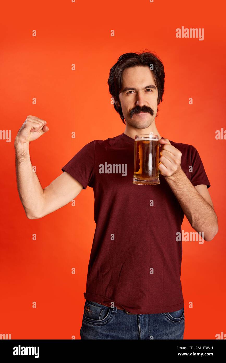 Portrait of emotive man with moustache posing with lager beer mug over ...