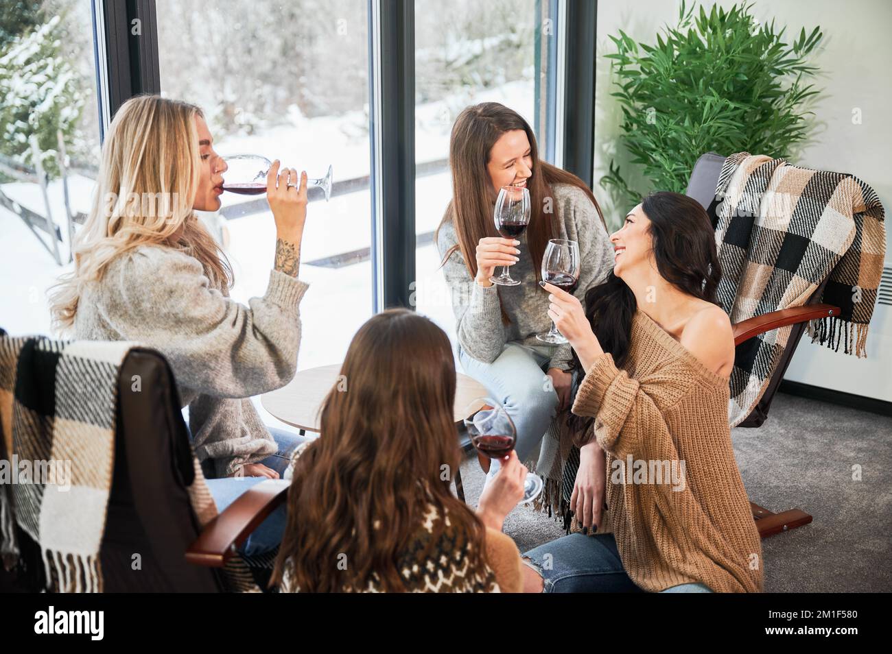 Young women enjoying winter weekends inside contemporary barn house ...