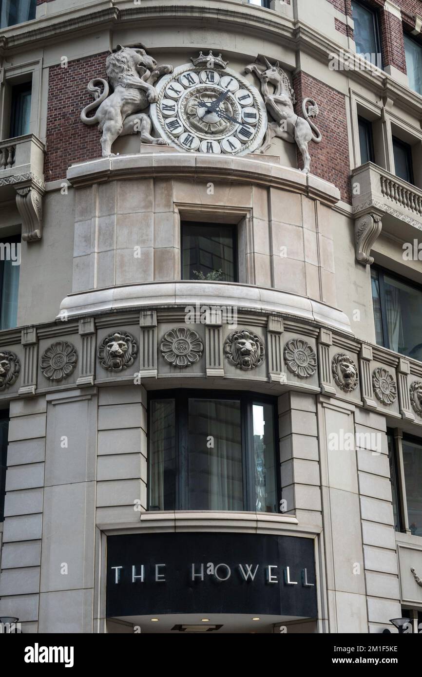 A huge ornate clock is above the front entrance of the apartment house ...