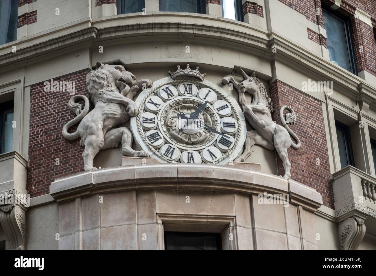 A huge ornate clock is above the front entrance of the apartment house ...