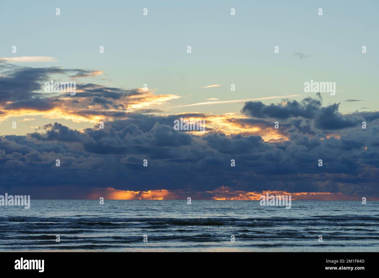 A beautiful view of the sea with a dramatic sunset in the background ...