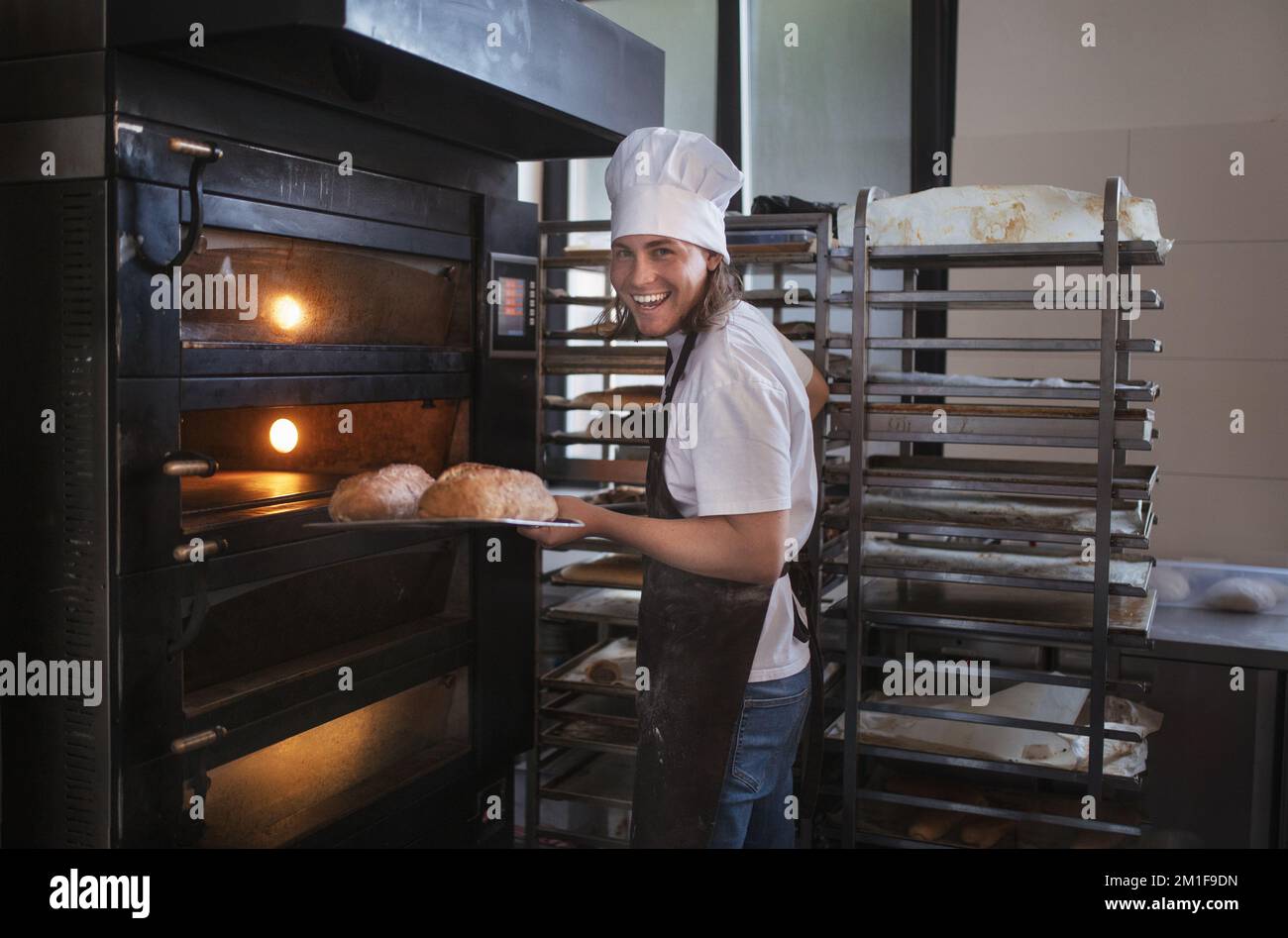 Young baker with chef cap preparing pastries in bakery Stock Photo - Alamy