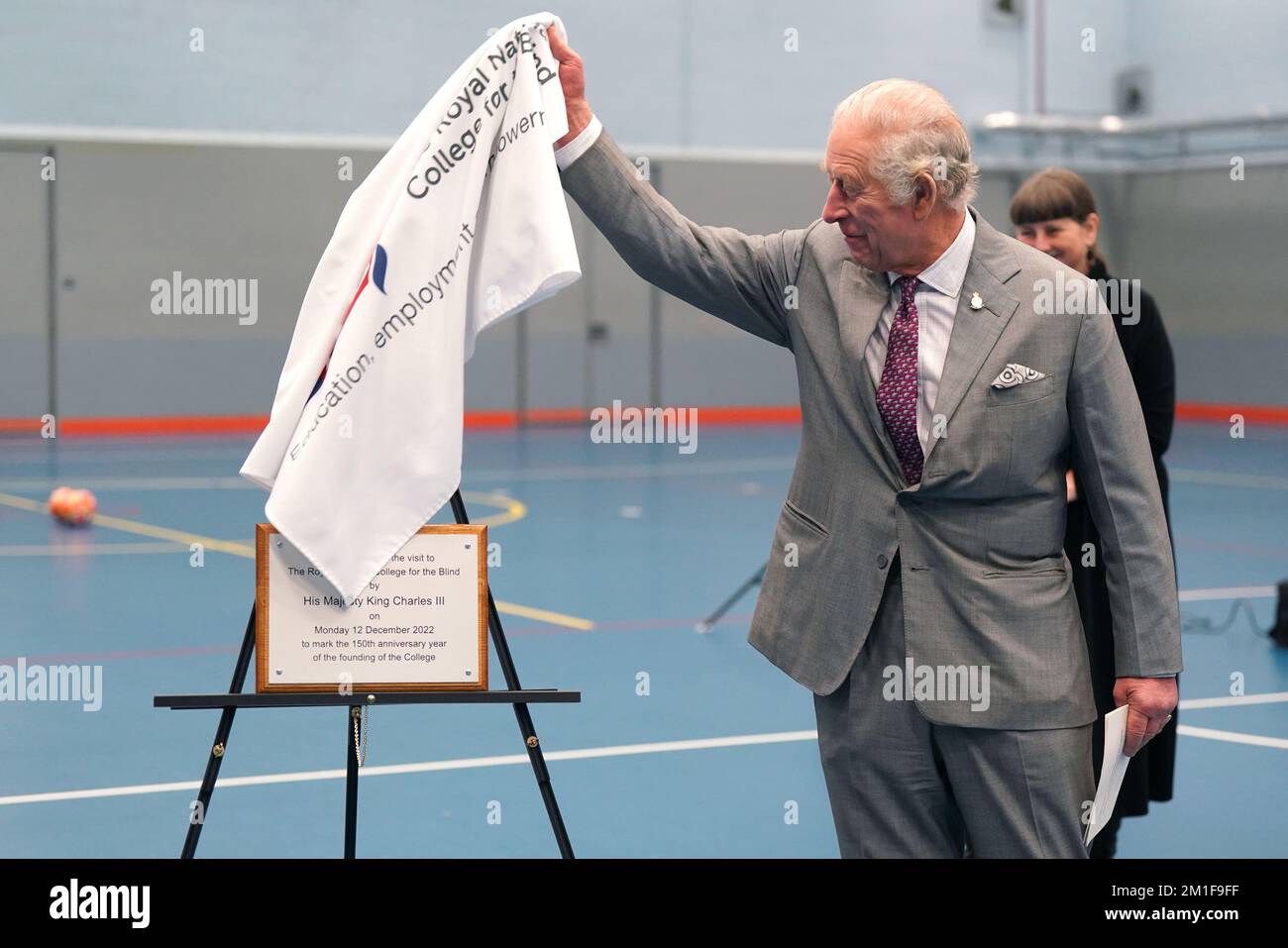 King Charles III unveils a plaque during his visit to Royal National ...