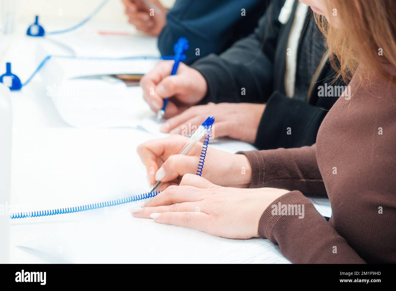 Woman fills out blank application form at table or signs contract ...