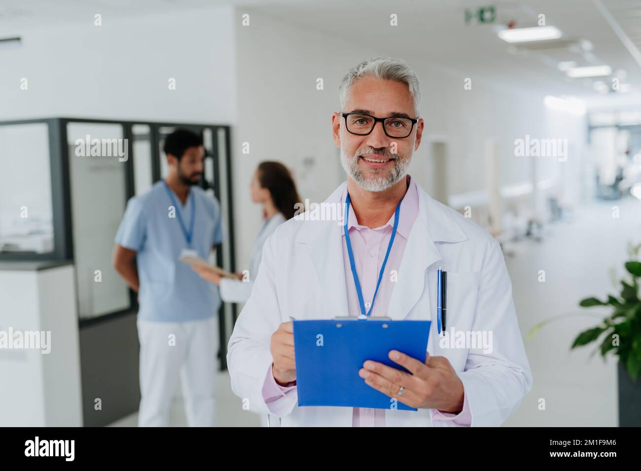 Portrait of happy doctor at hospital corridor Stock Photo - Alamy