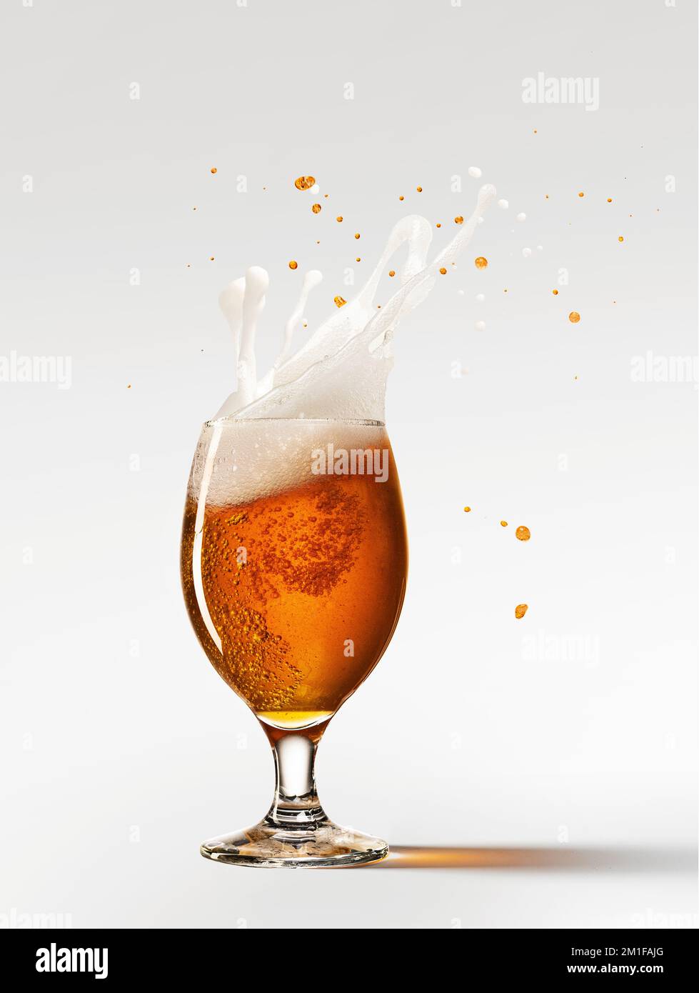 Splashes of taste. Glass with light, lager foamy beer over isolated ...