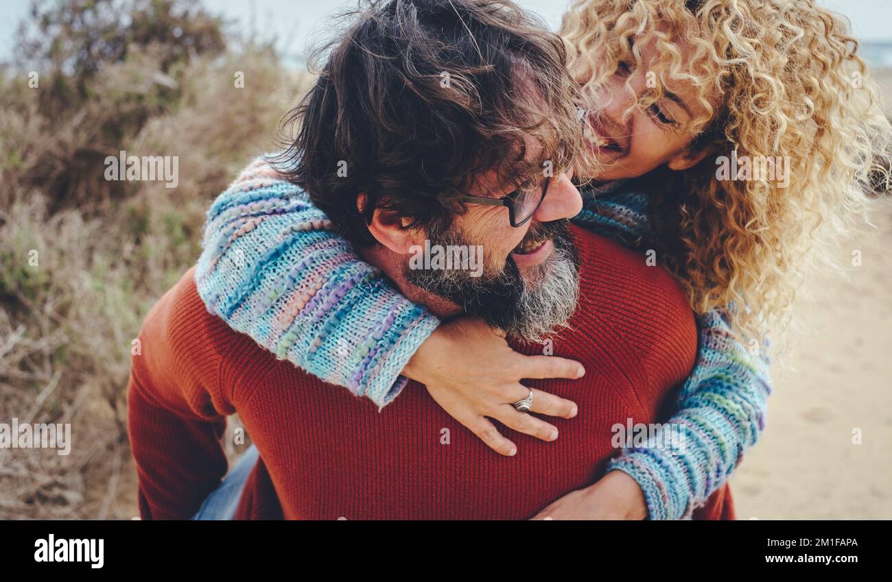 One man carry overjoyed woman in piggyback in outdoor leisure activity ...