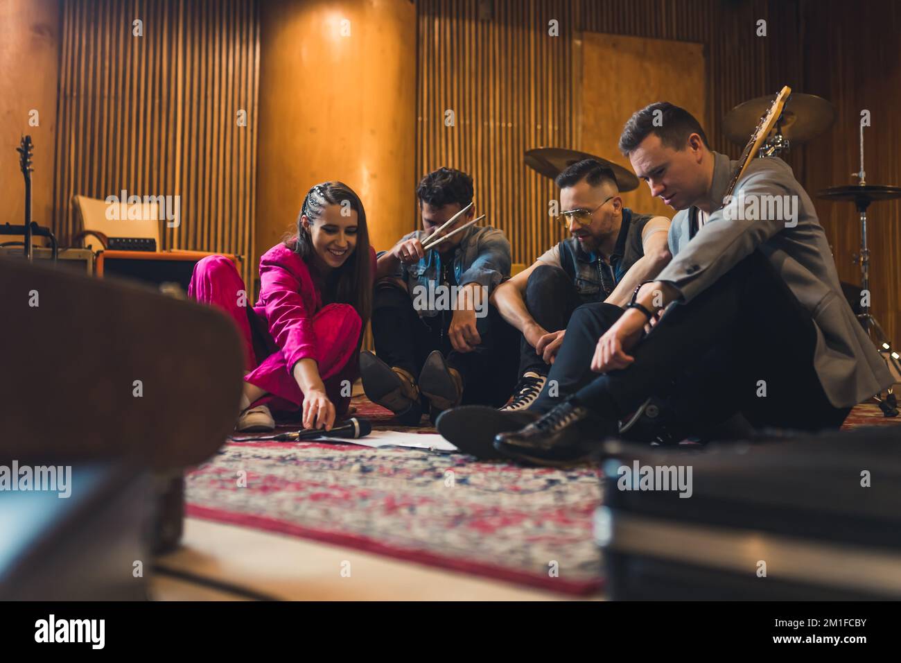 full shot of a four musicians sitting on the floor and writing a new ...