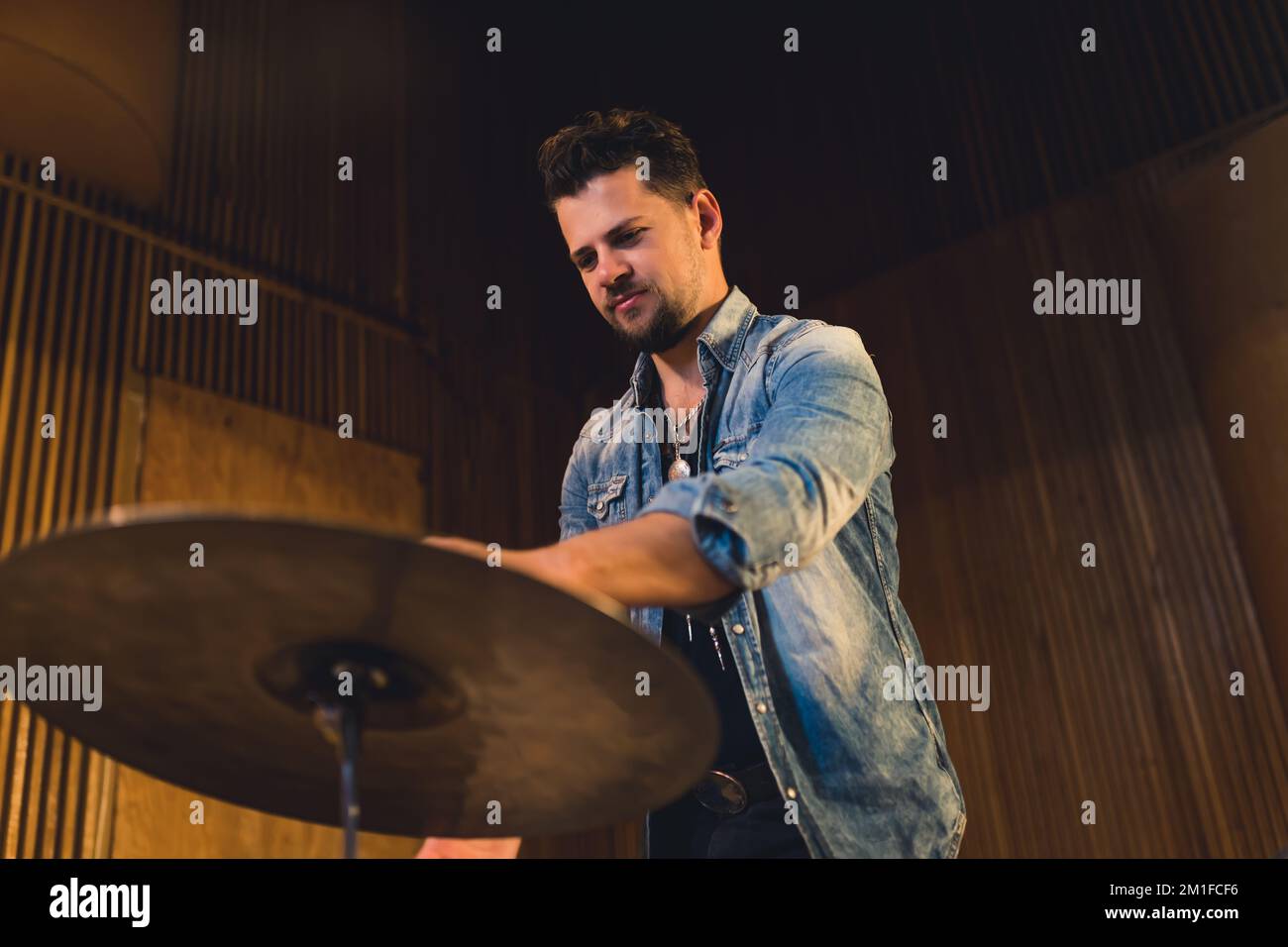 medium shot of a young drummer playing on rehearsal, musical studio ...