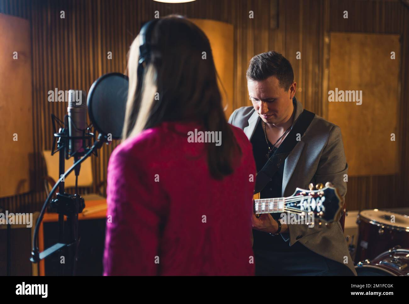 medium shot of a singer-woman and a guitarist-man in the recording ...
