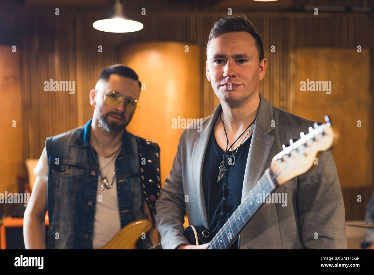 medium shot of two guitarists of a music band posing on repetition ...