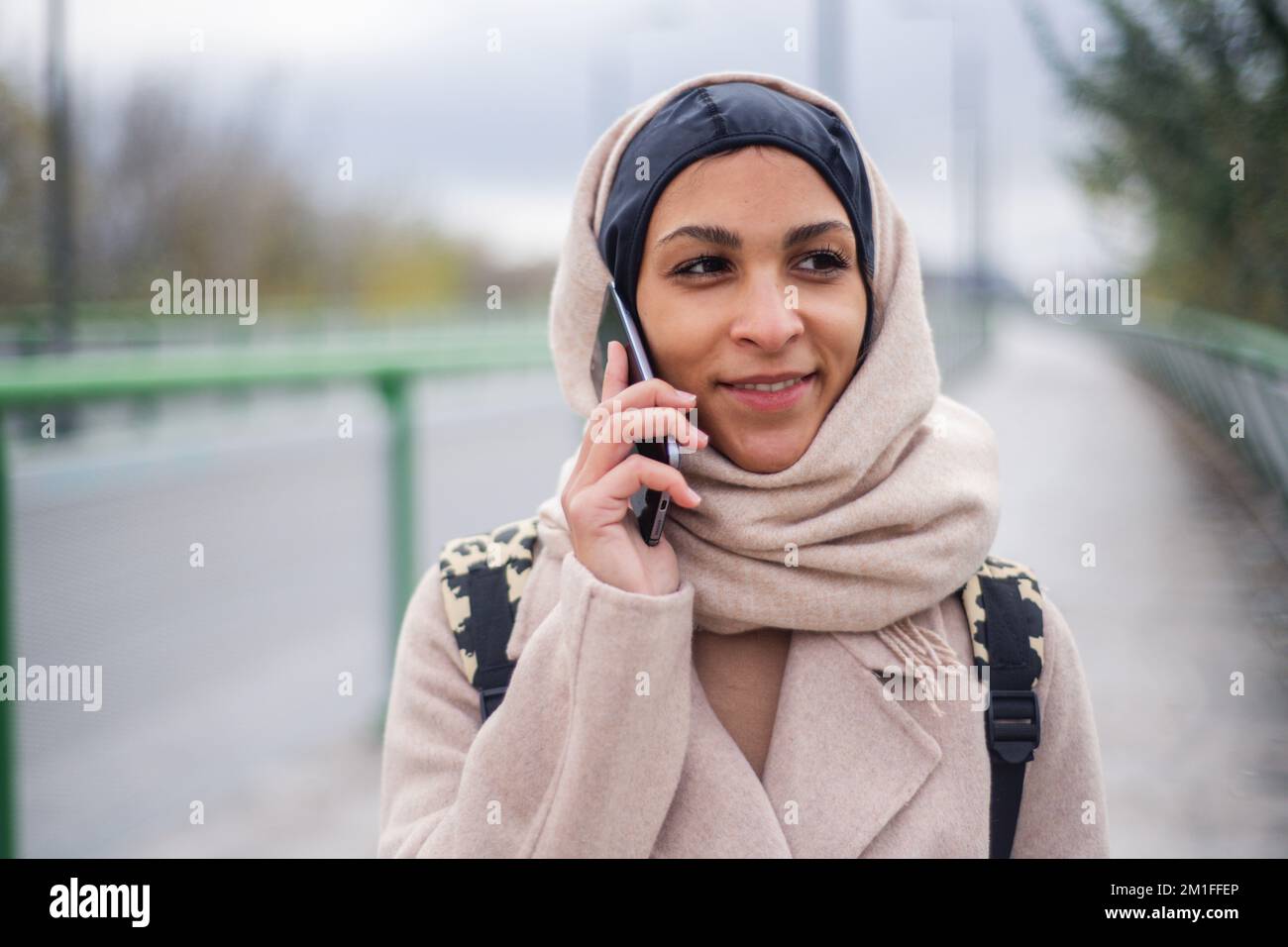 Portrait of young muslim woman walking and calling in a city Stock ...