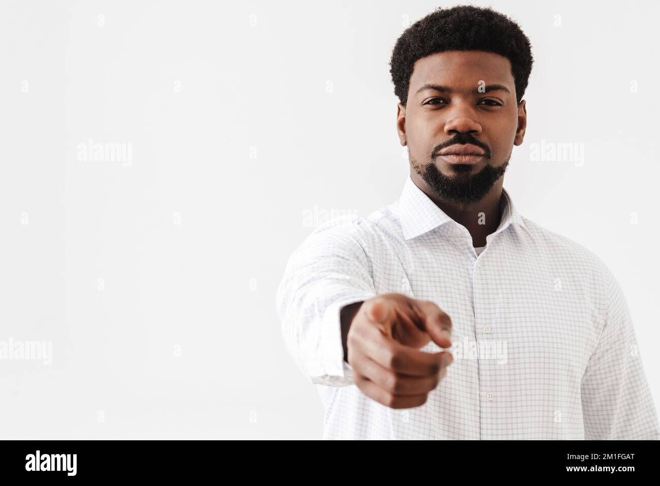 Black mid man wearing shirt looking and pointing finger at camera ...