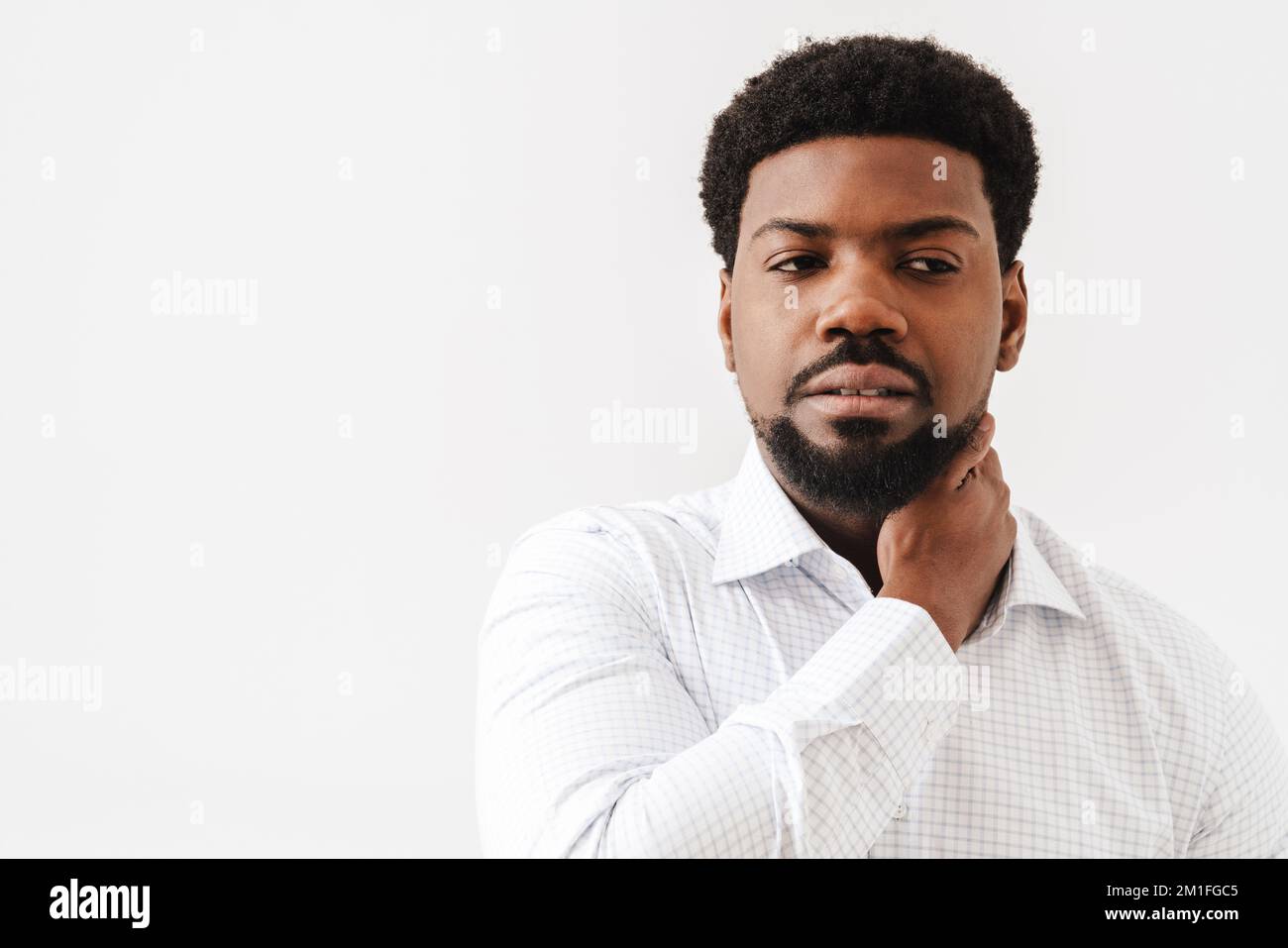 Black mid man wearing shirt posing and holding his neck isolated over ...
