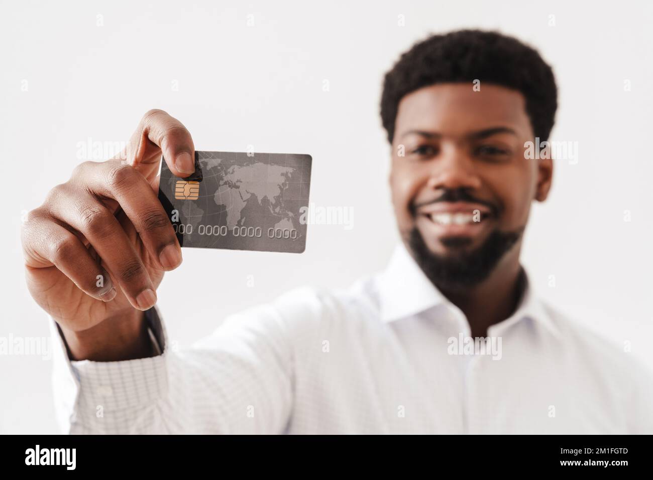 Black mid man smiling and showing credit card at camera isolated over ...