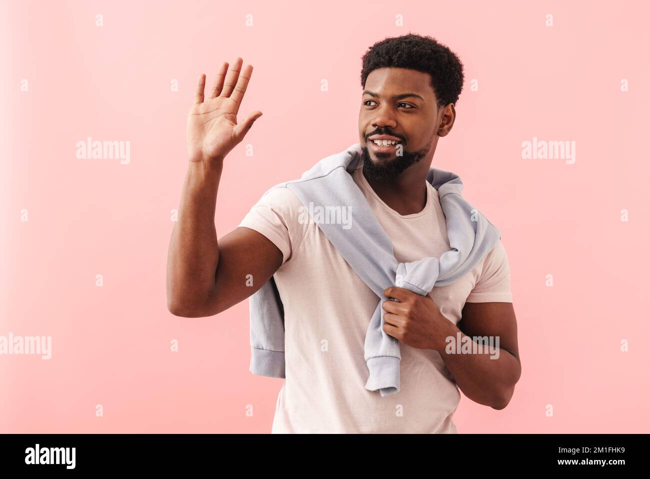 Black mid man wearing t-shirt smiling and waving hand isolated over ...