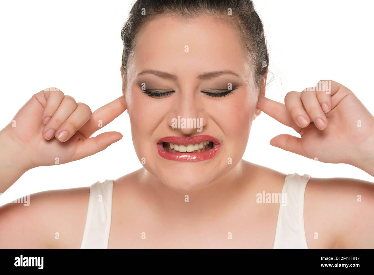 Photo of upset chubby young woman cover fingers ears loud noise scream isolated on white studio ...