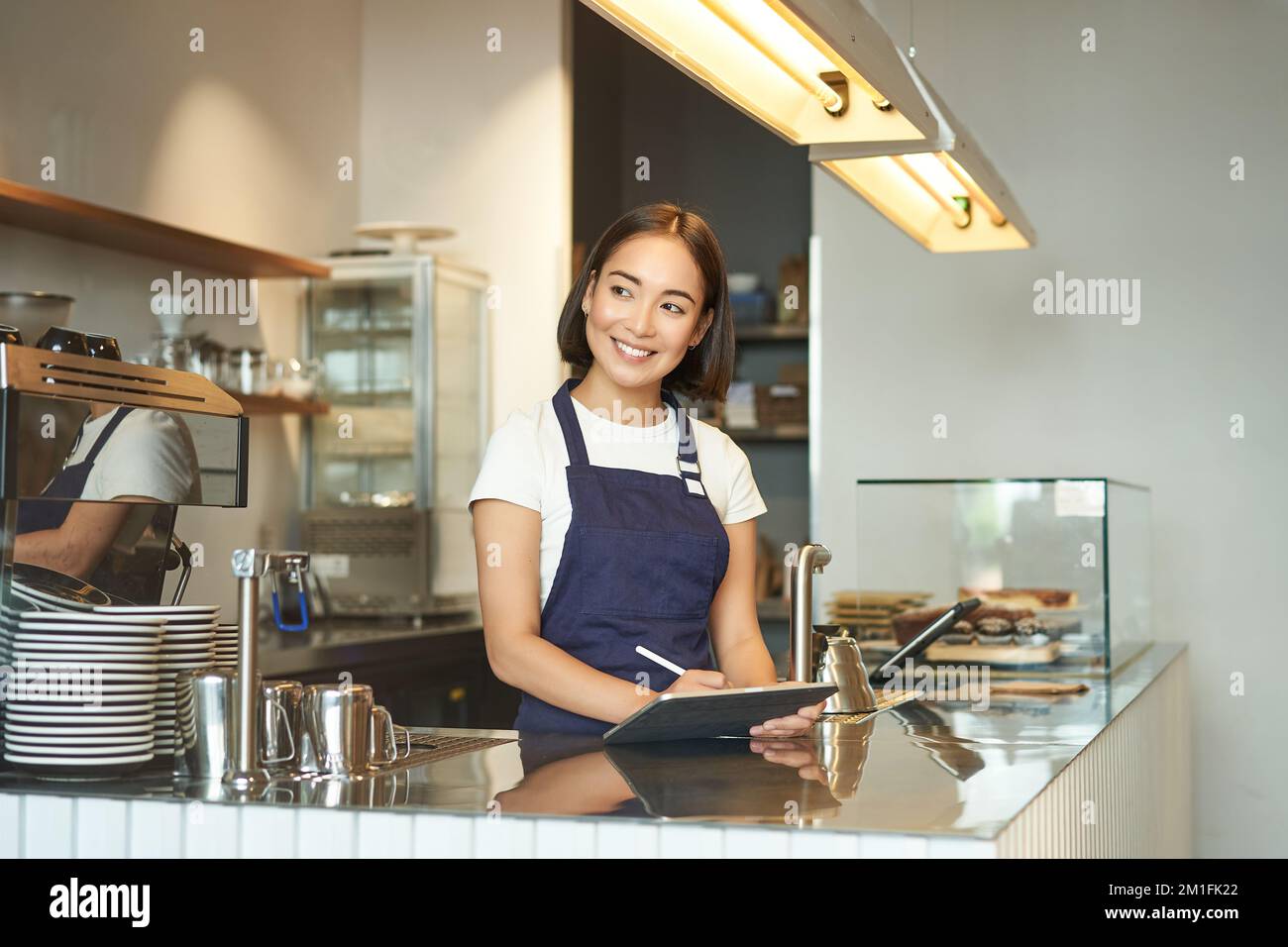 Portrait of beautiful asian girl smiling, barista in cafe working ...