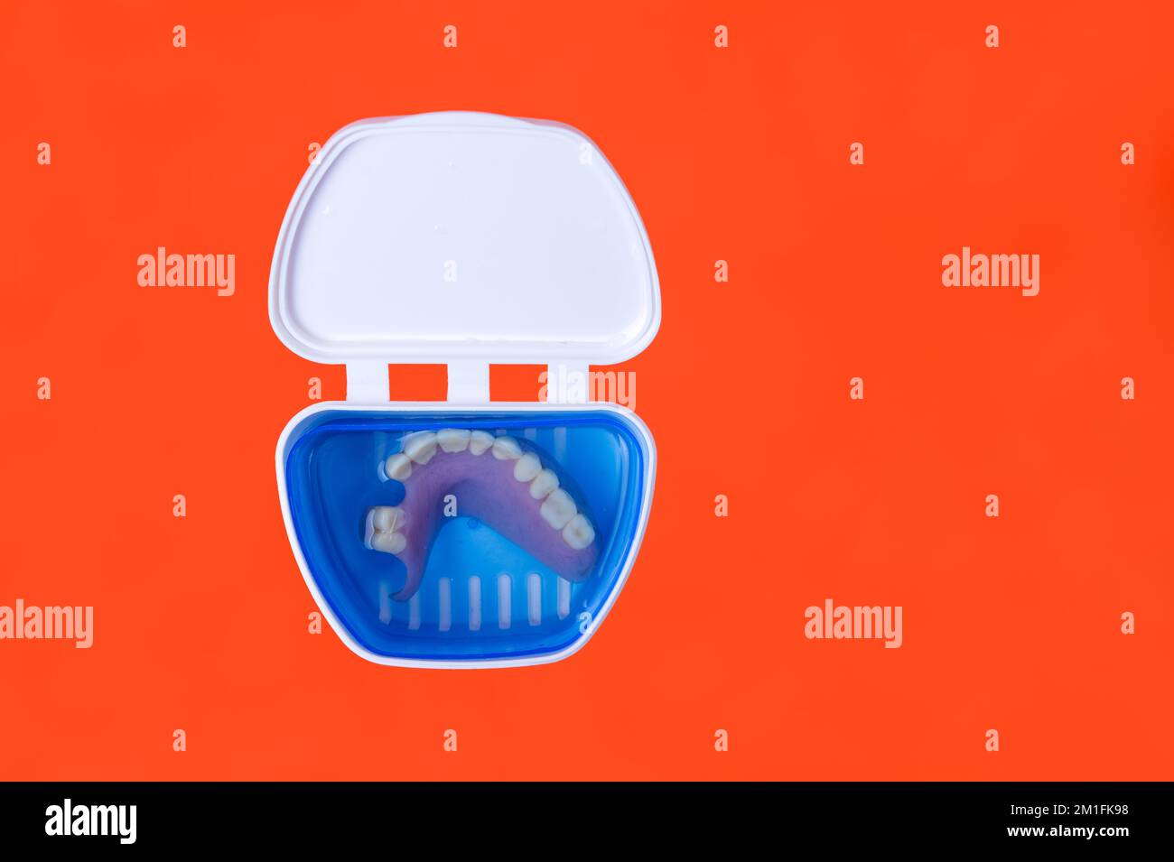 white hinged open denture container with false teeth isolated on an ...