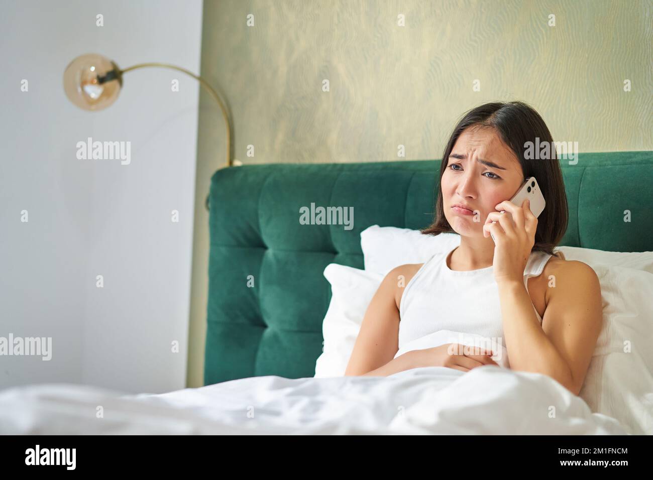 Portrait of concerned asian woman holding mobile phone, receive bad ...