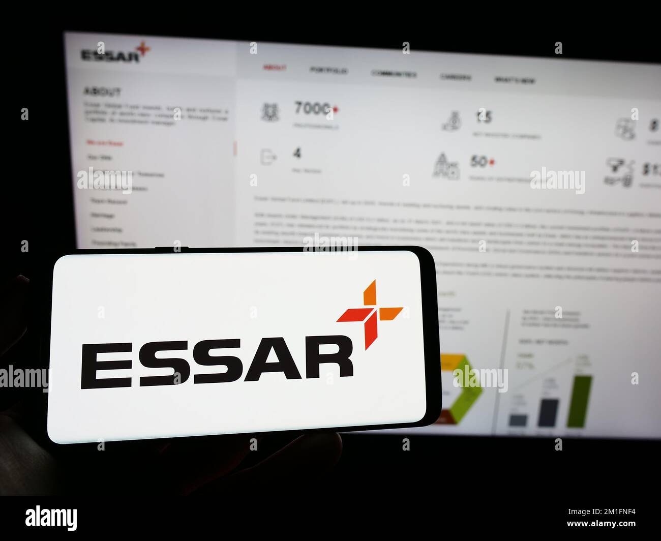 Person holding cellphone with logo of Indian conglomerate Essar Group ...