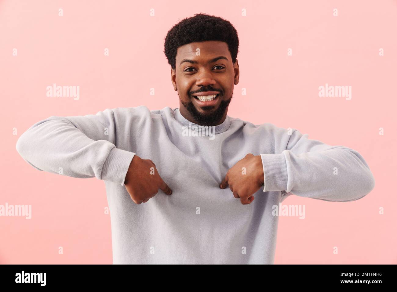 Black mid man with beard smiling and pointing fingers at himself ...