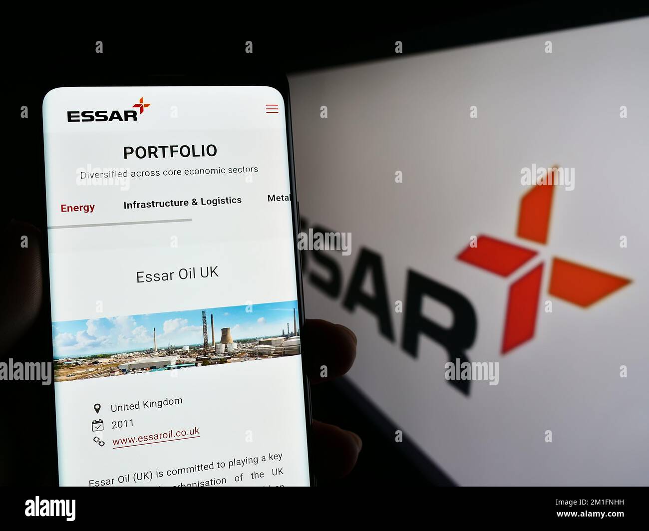 Person holding smartphone with website of Indian conglomerate Essar ...