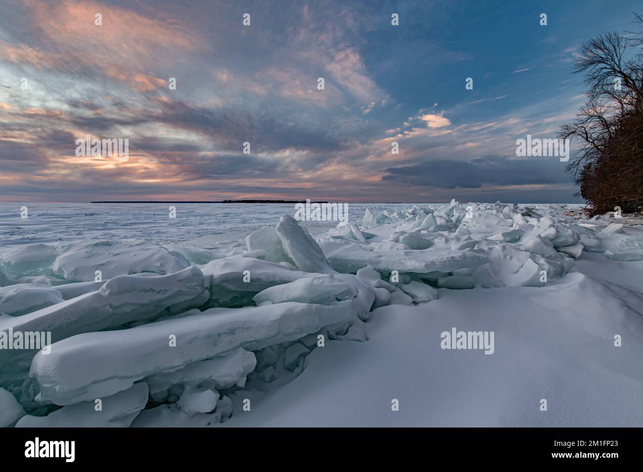 The sun sets into the sky over Green Bay from Peninsula State Park ...
