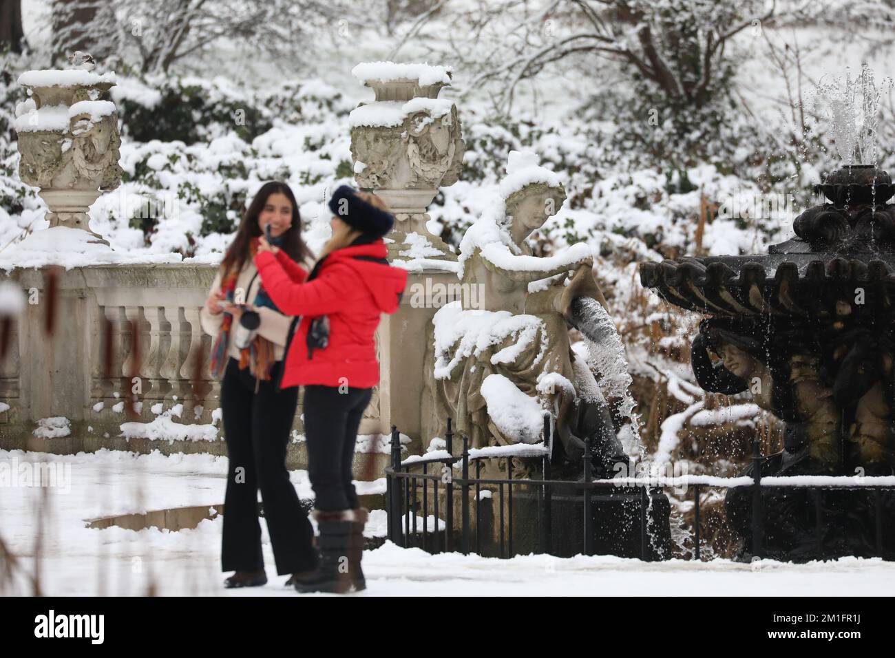 People walk through the snow in Hyde Park, central London. Snow and ice ...