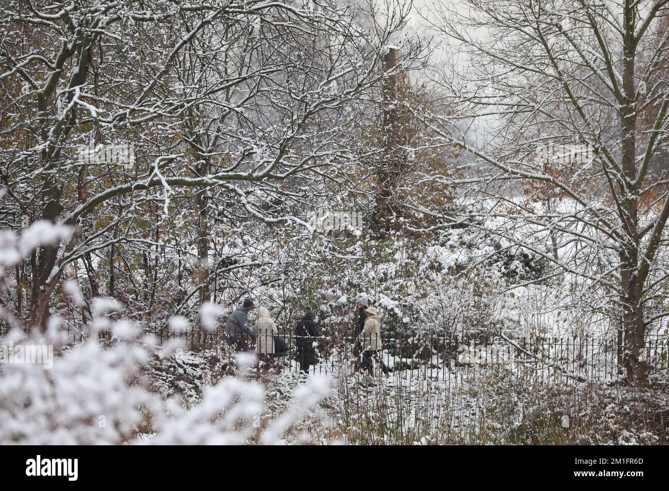 People walk through the snow in Hyde Park, central London. Snow and ice ...