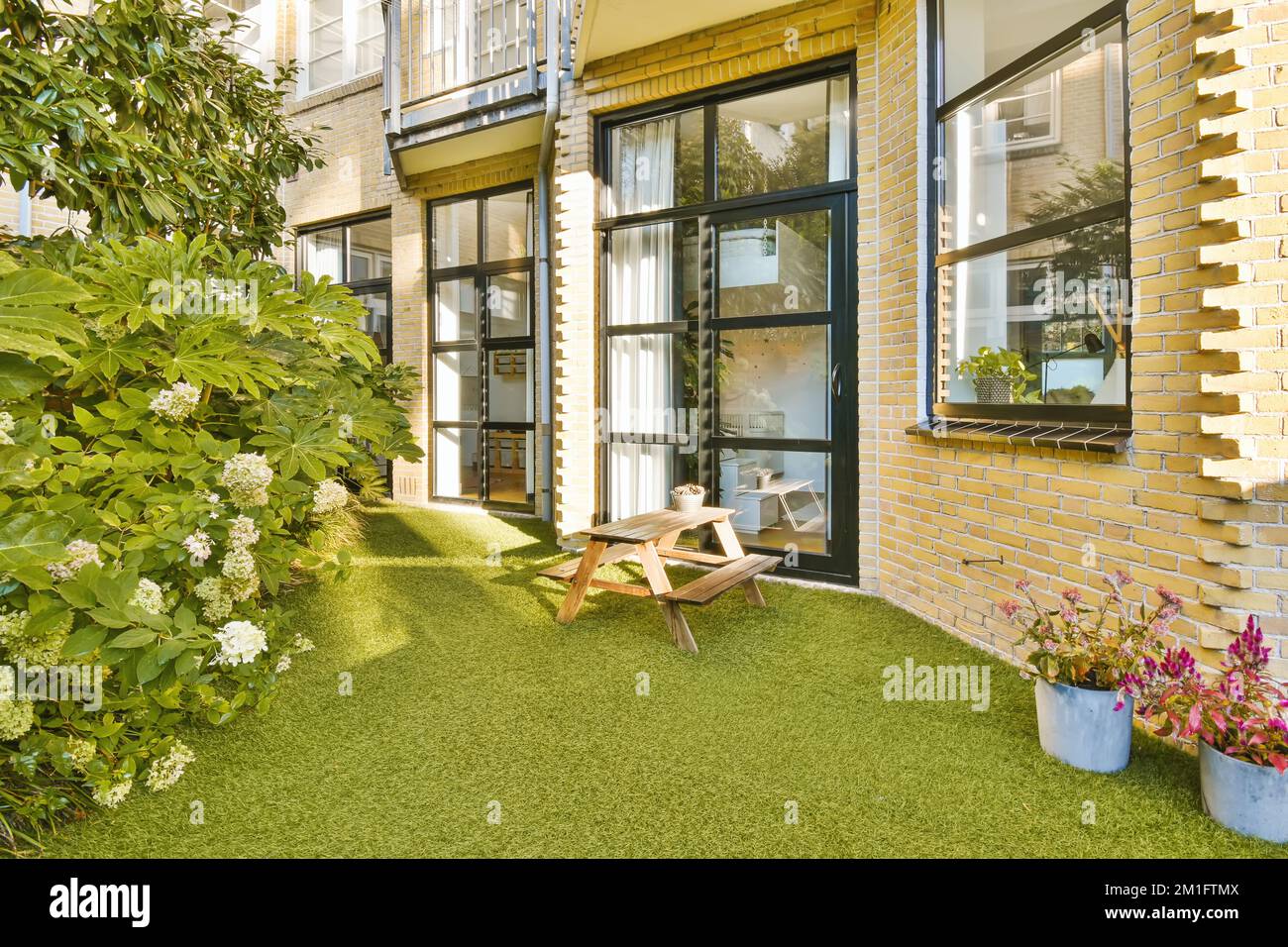 an outside area with green grass and flowers on the ground next to a ...