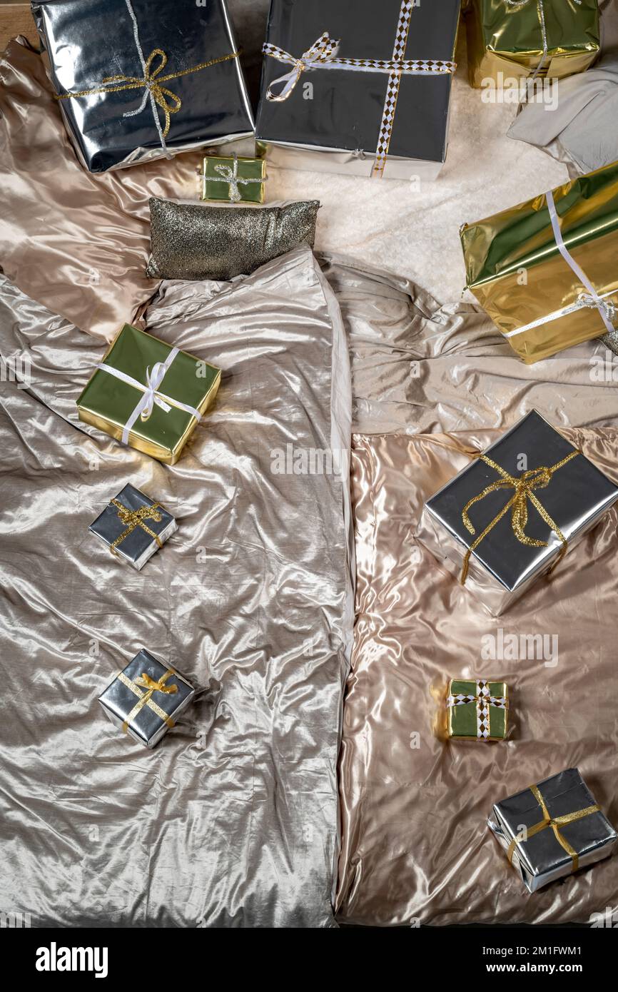 High angle view of gift boxes wrapped with silver and golden papers ...
