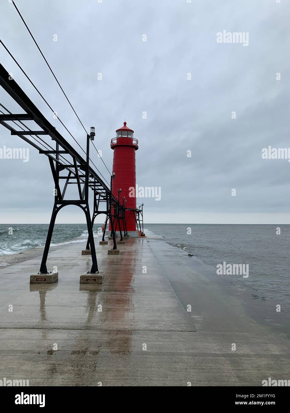 A landscape view of the Grand Haven Lighthouse and pier in lake ...