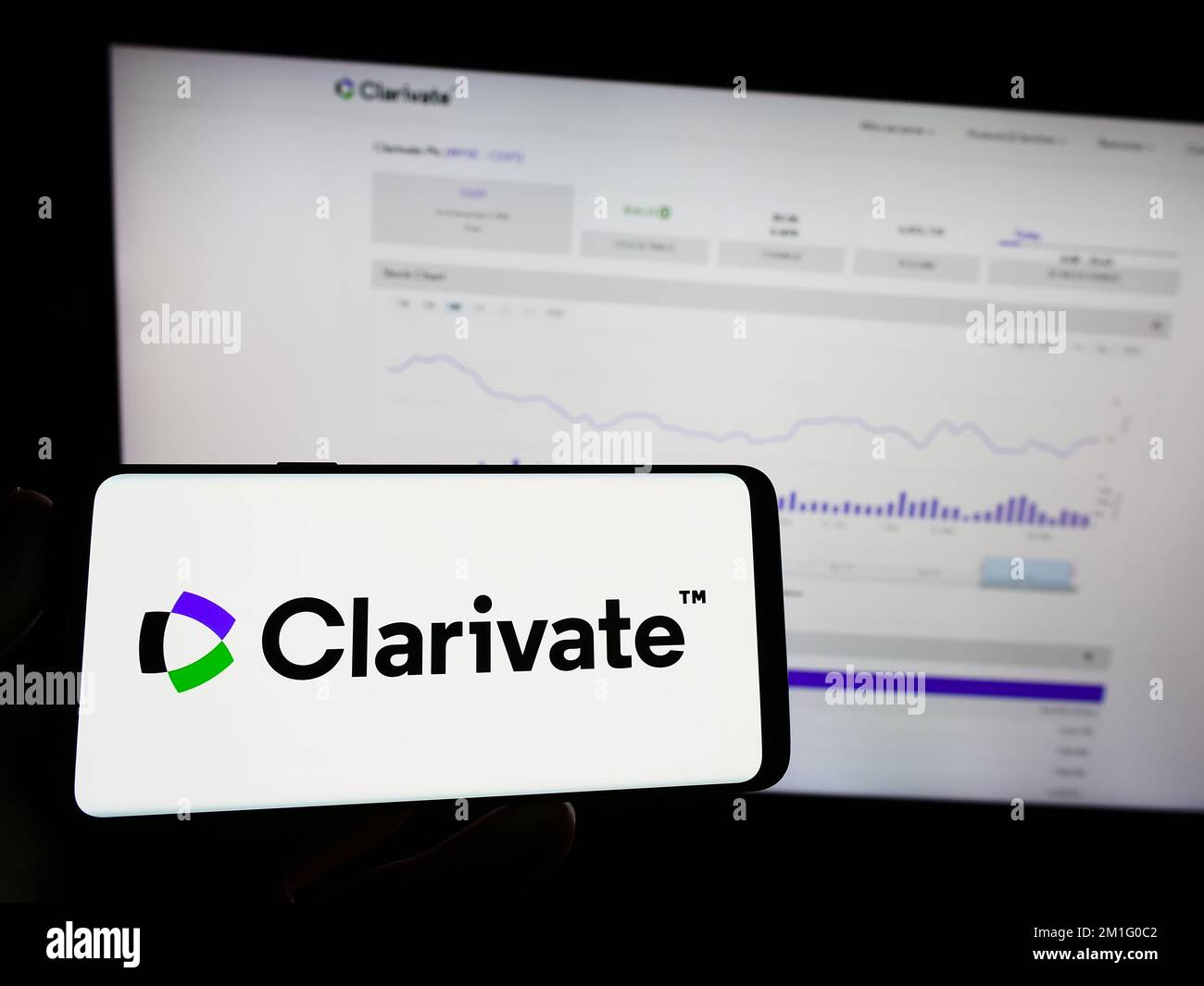 Person holding mobile phone with logo of analytics company Clarivate ...