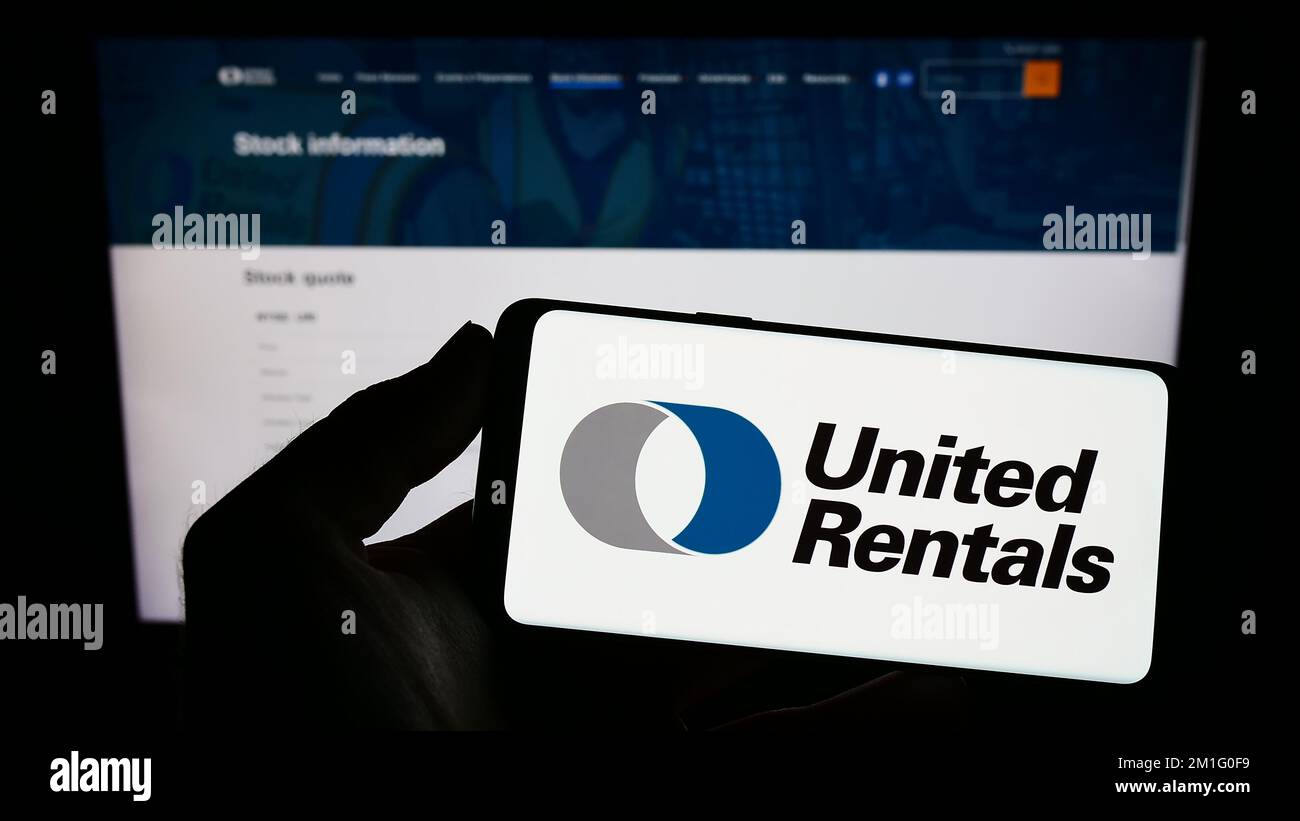 Person holding mobile phone with logo of US equipment rental company ...