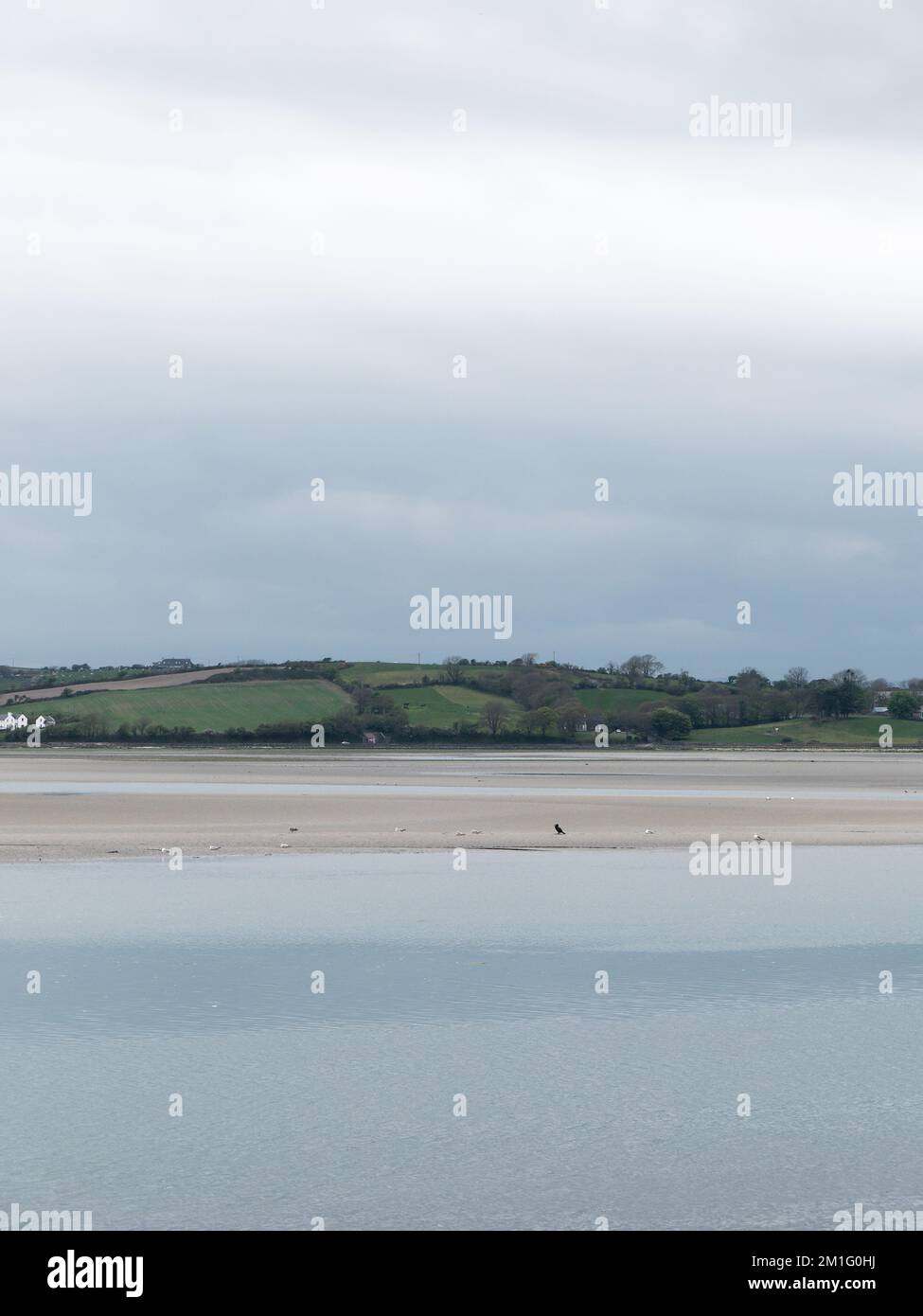 A large sand spit on the ocean shore. Sea shoal. Cloudy sky over the ...
