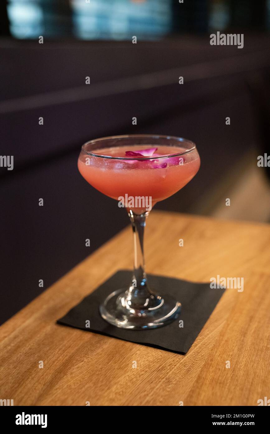 A beautiful cocktail of guava hibiscus martini with orchid garnish ...