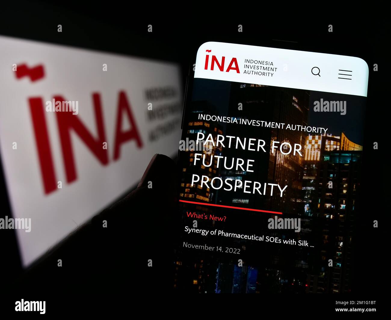 Person holding cellphone with website of Indonesia Investment Authority ...