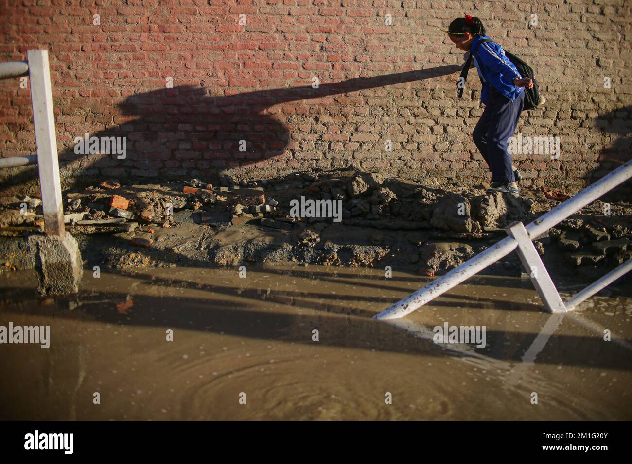 Nepal. 12th Dec, 2022. School childrens crosses a flooded road after ...