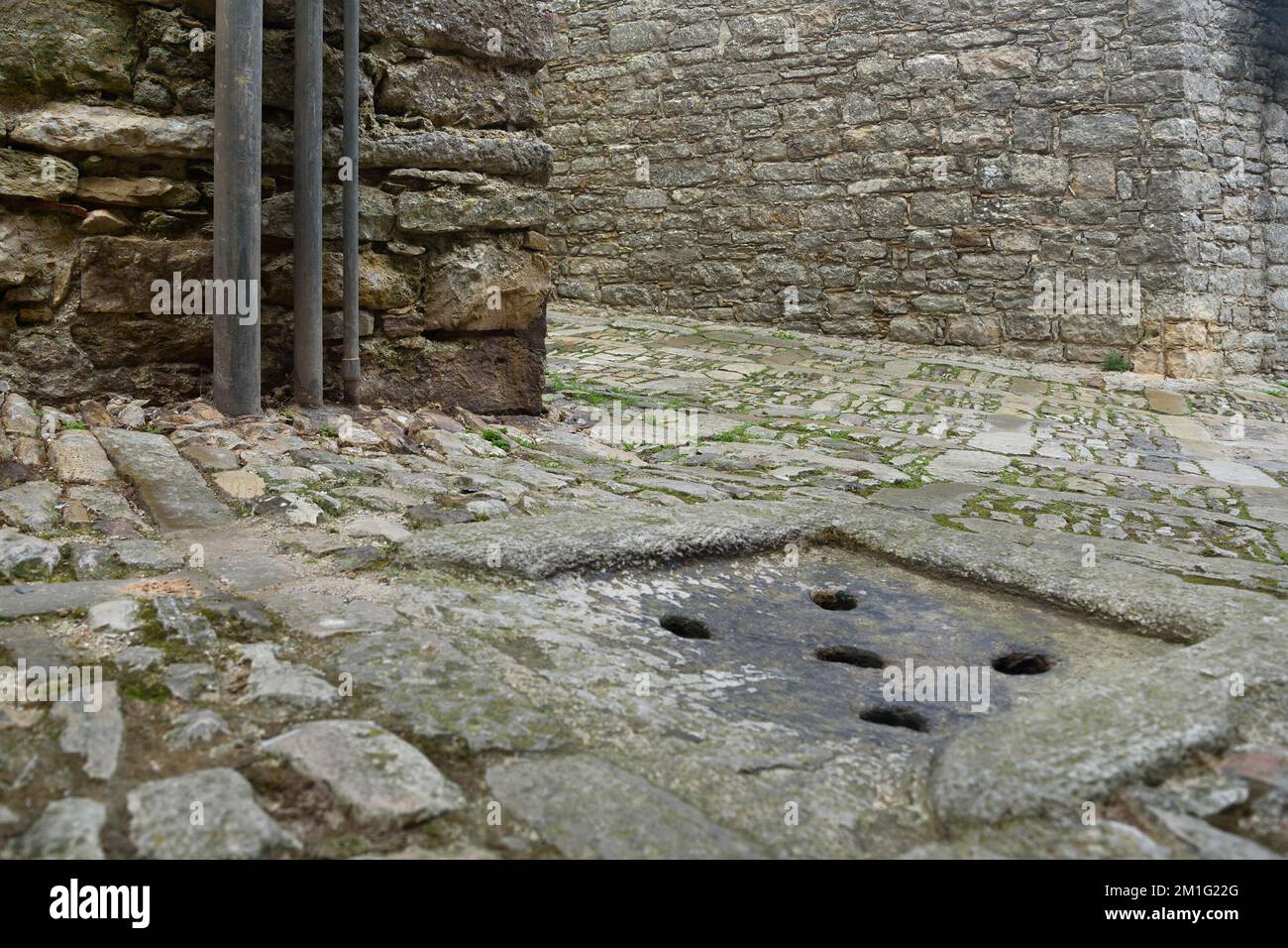 Street sewage on the stone road Stock Photo - Alamy