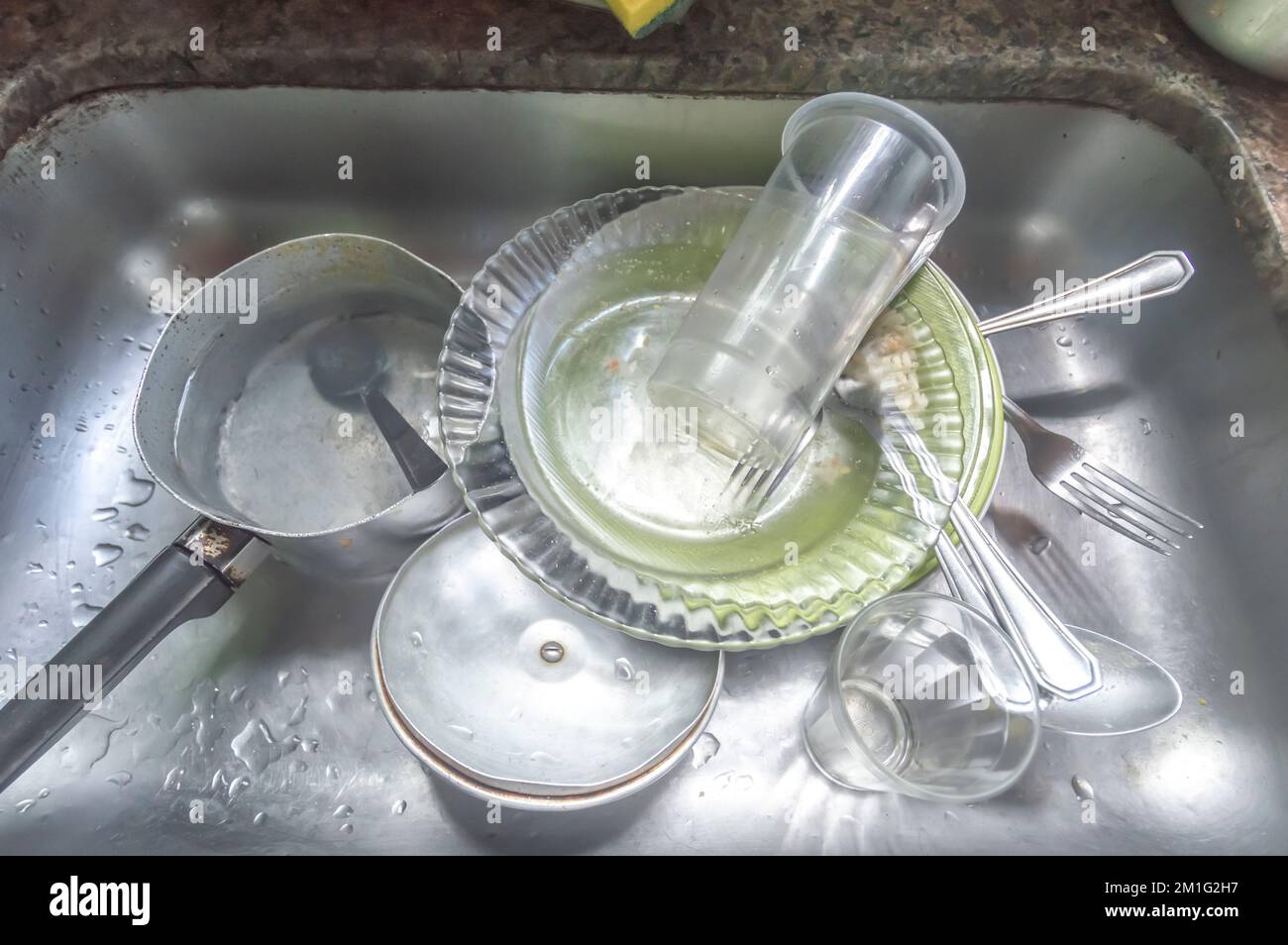 Dirty dishes, dishes, cutlery and dirty pots in a simple home sink,real ...